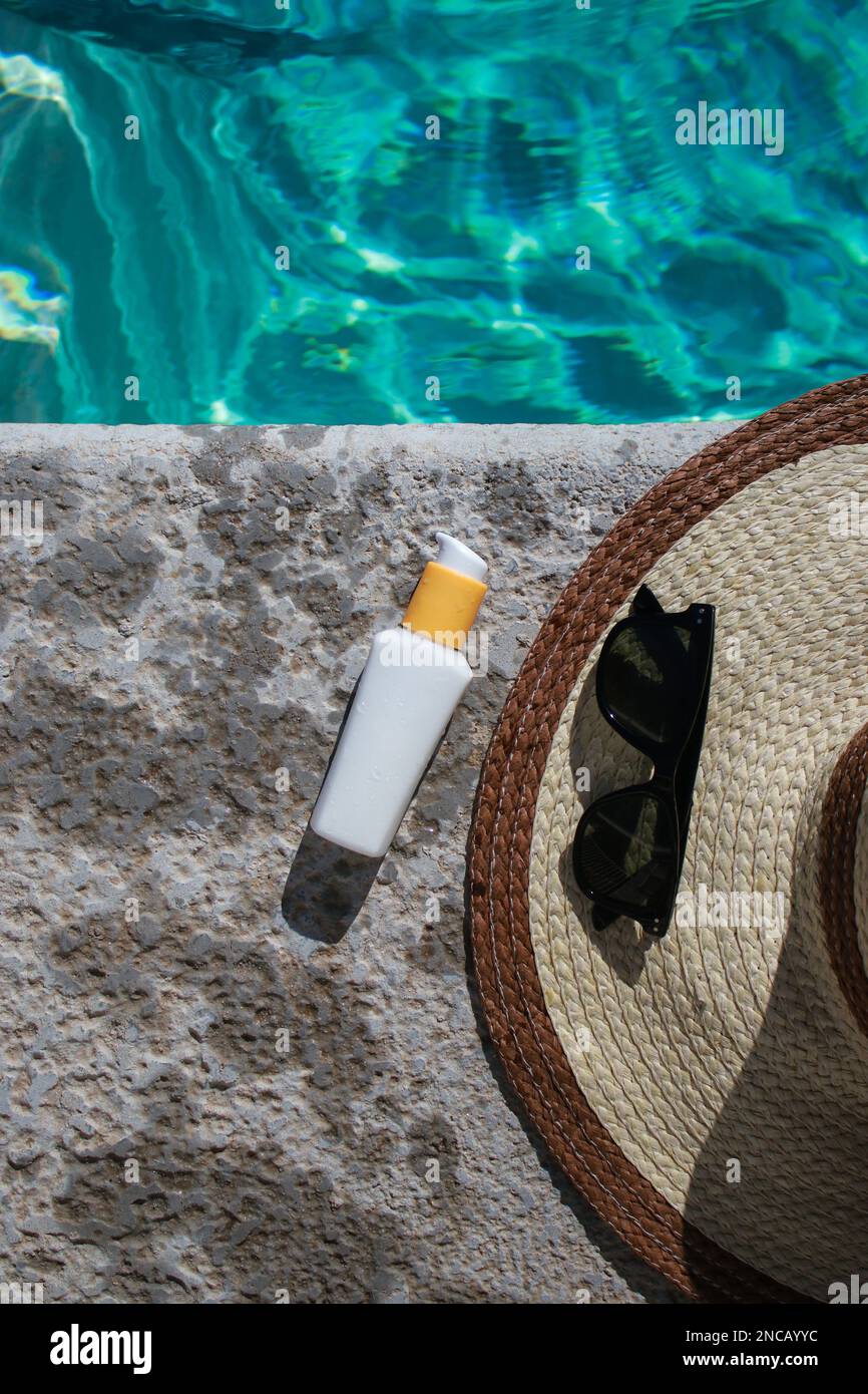 white mock up sunscreen bottle at the pool with sunglasses and summer ...