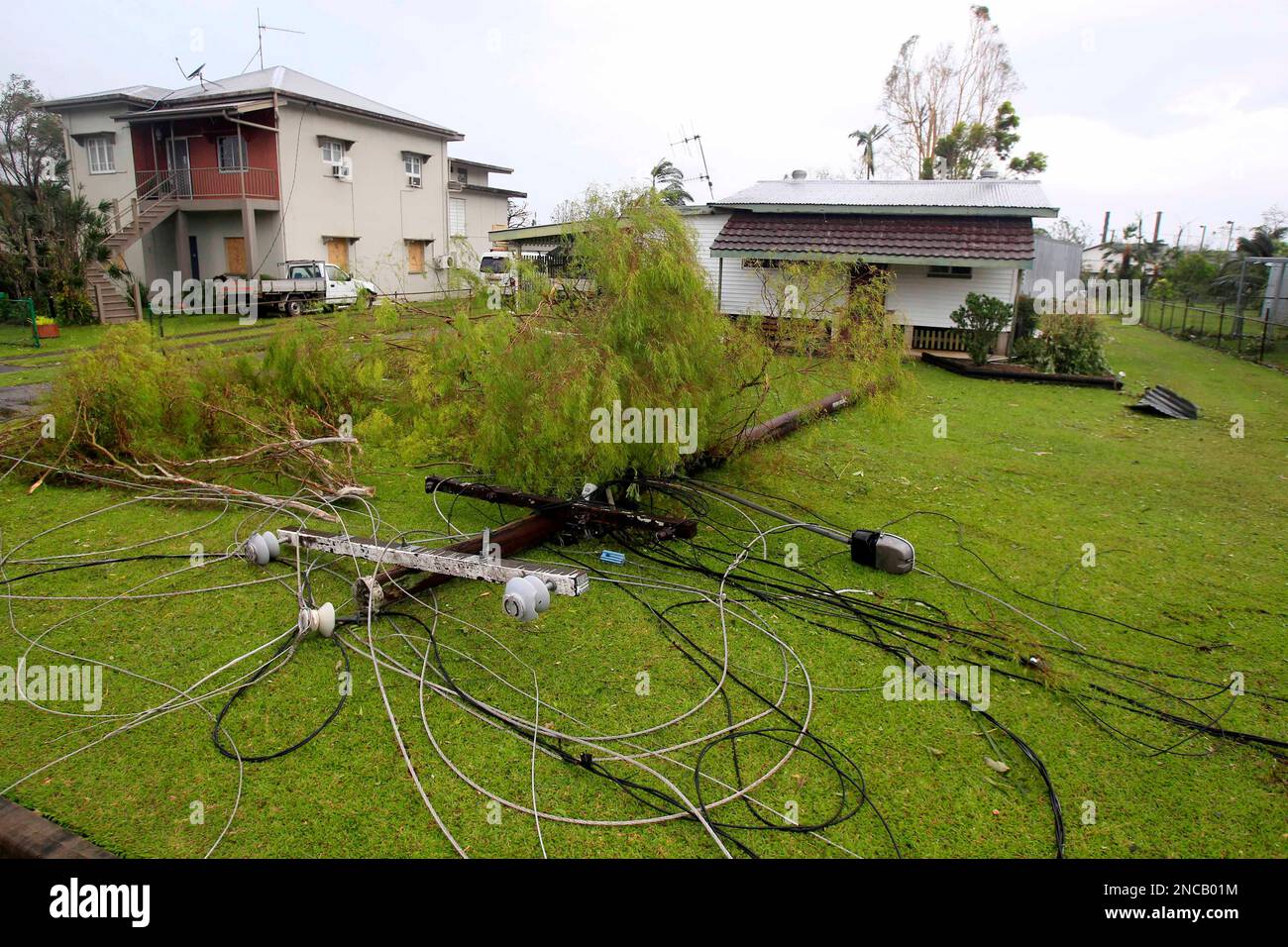 A power pole lays across a lawn at a home in Tully, Australia, Thursday ...