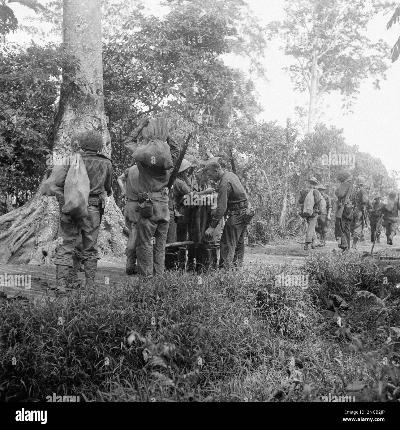 American and Australian soldiers work together in carrying food out to ...