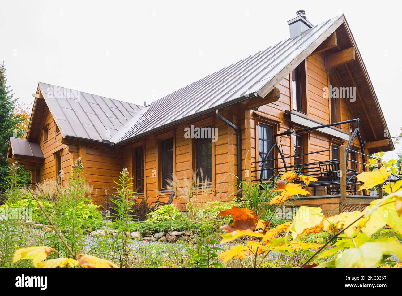 Piece sur piece Scots pine log home facade with brown standing seam ...