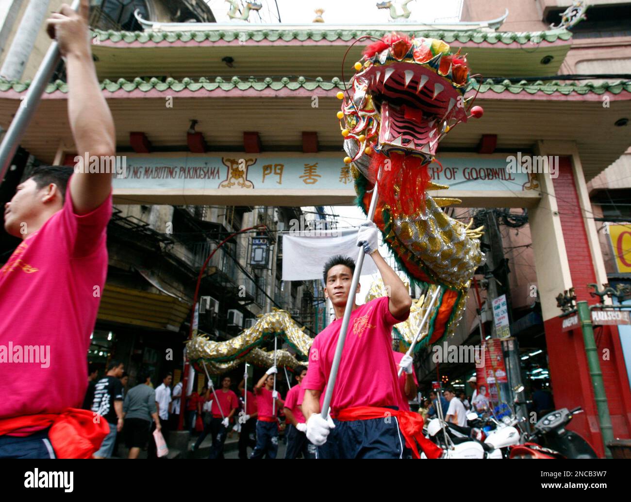 Dragon dance performers pass under an arch on the eve of the ...