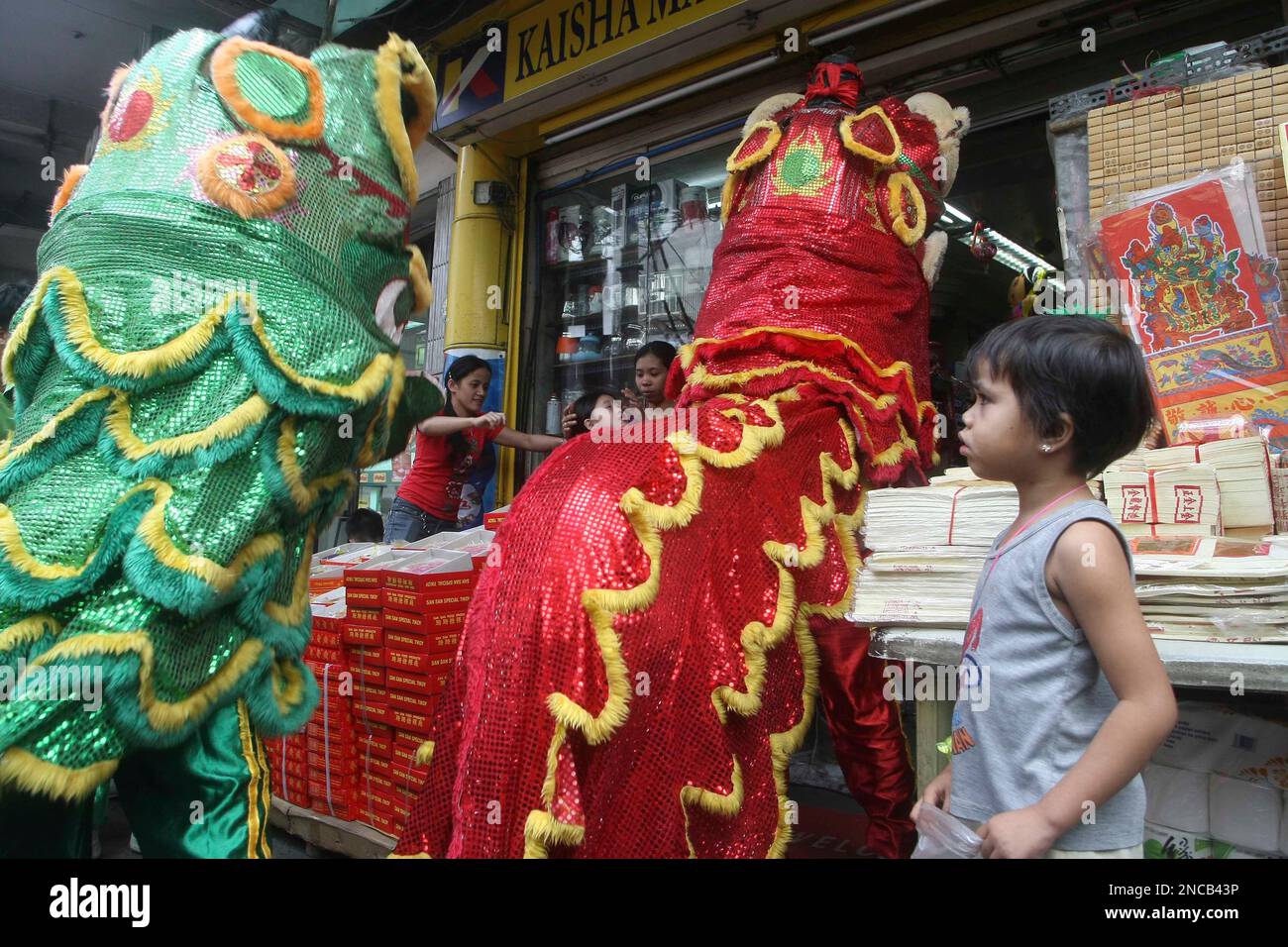 A boy watches as dragon dancers perform at a business establishment at ...