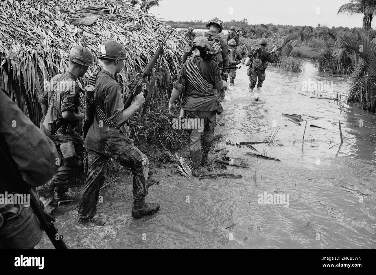 U.S. soldiers trudge through a rice paddy near Saigon in search of Viet ...