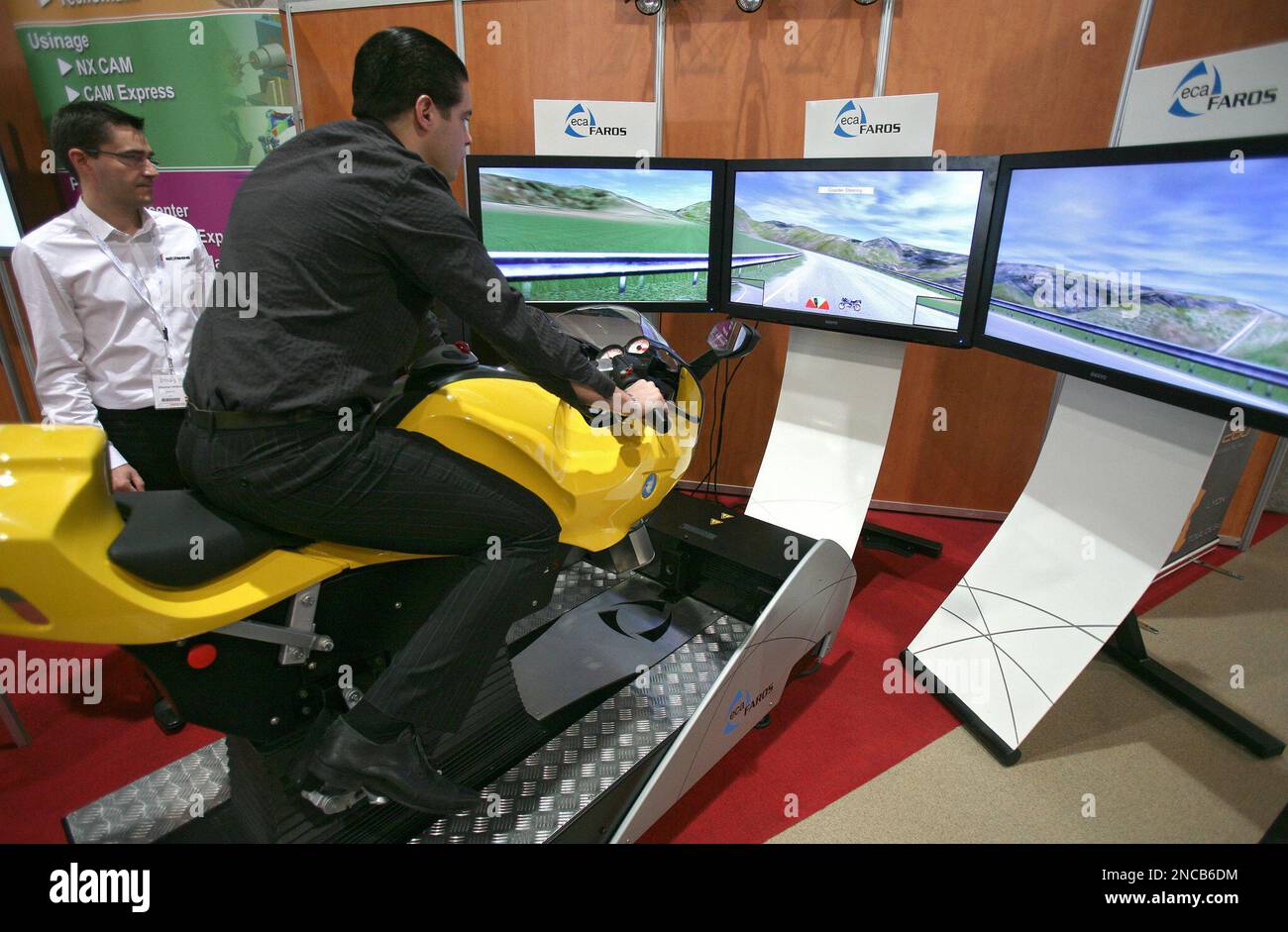 A man rides motorcycle simulator in front 3D screens during the ...