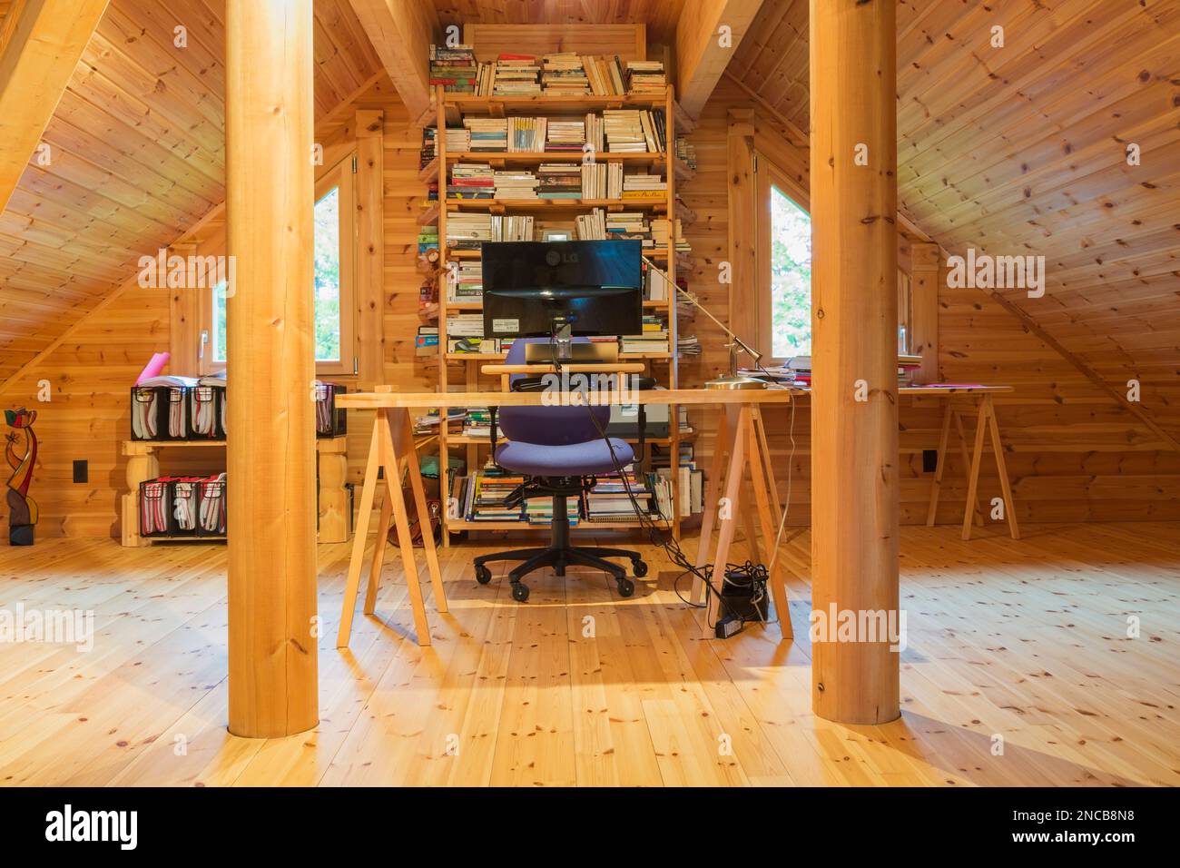 Wooden desk table with computer and bookcase in home office set-up on ...