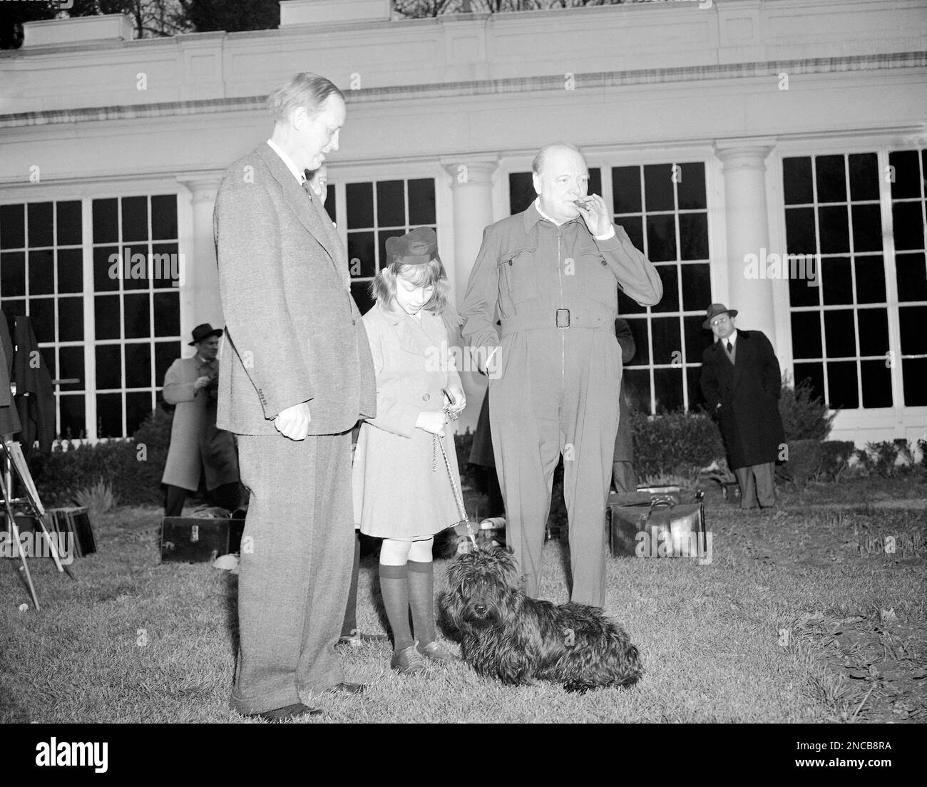 Winston Churchill displayed his “siren suit”, a sort of zippered coverall, for rapid air radio ...