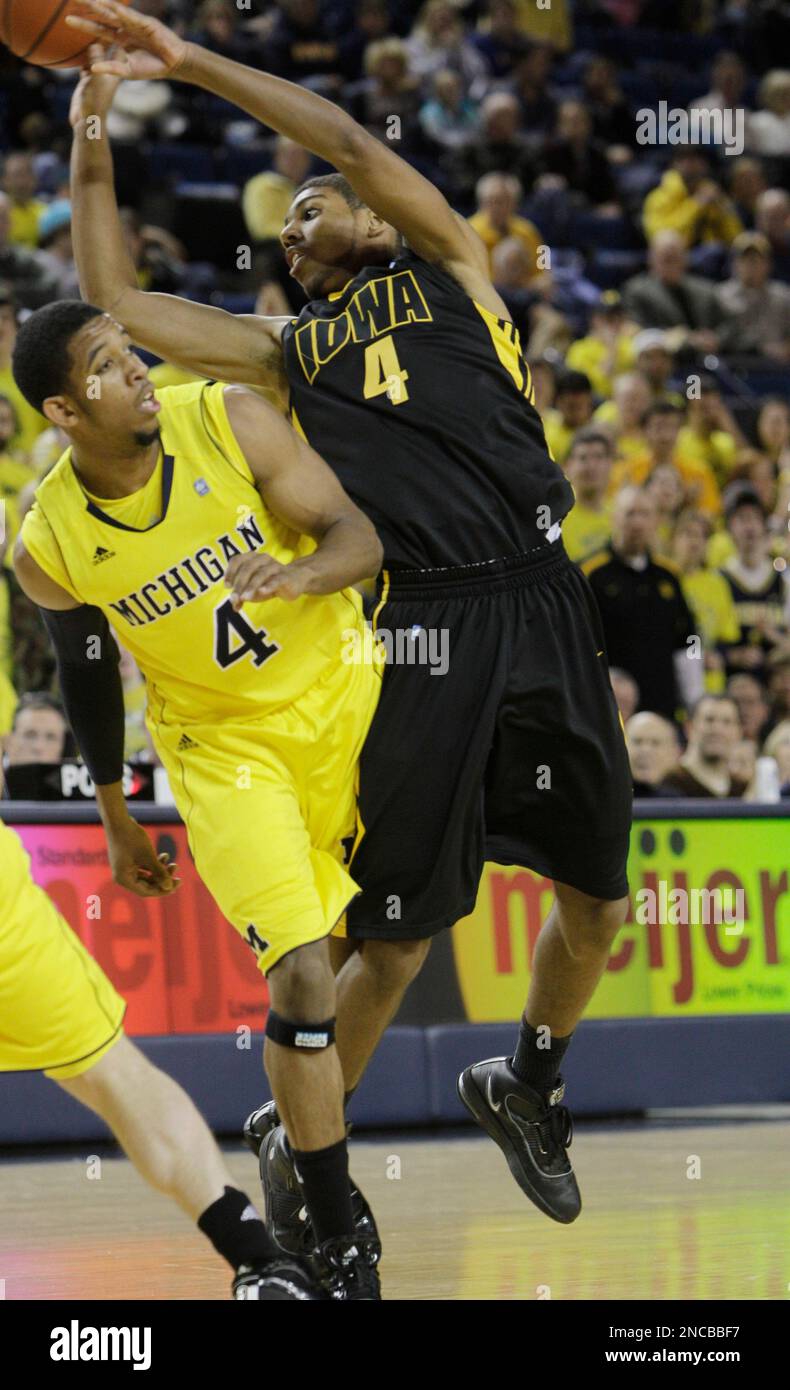 Iowa guard Roy Devyn Marble, right, passes around Michigan guard Darius ...
