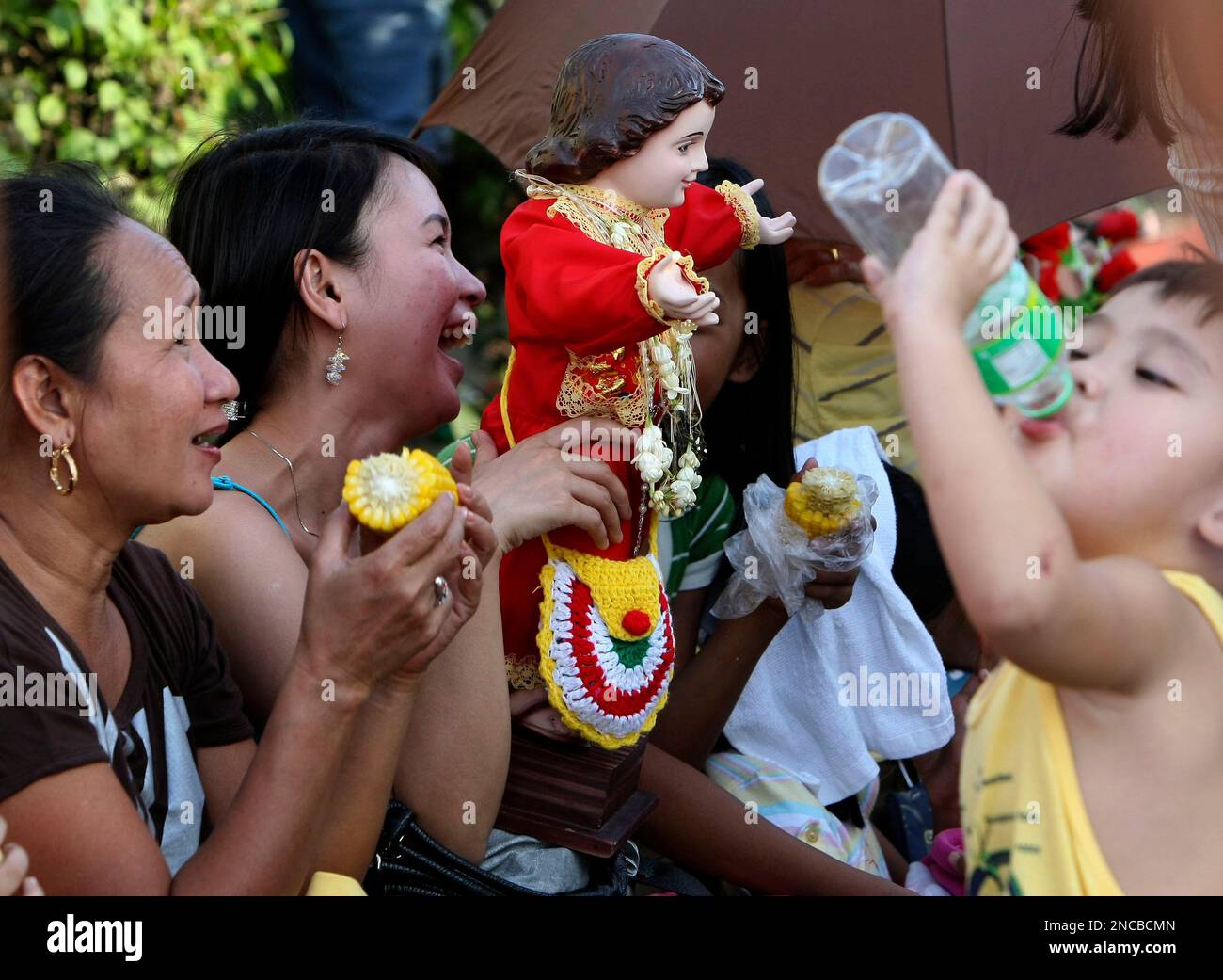 Catholic devotees display an image of the Child Jesus as they watch a ...