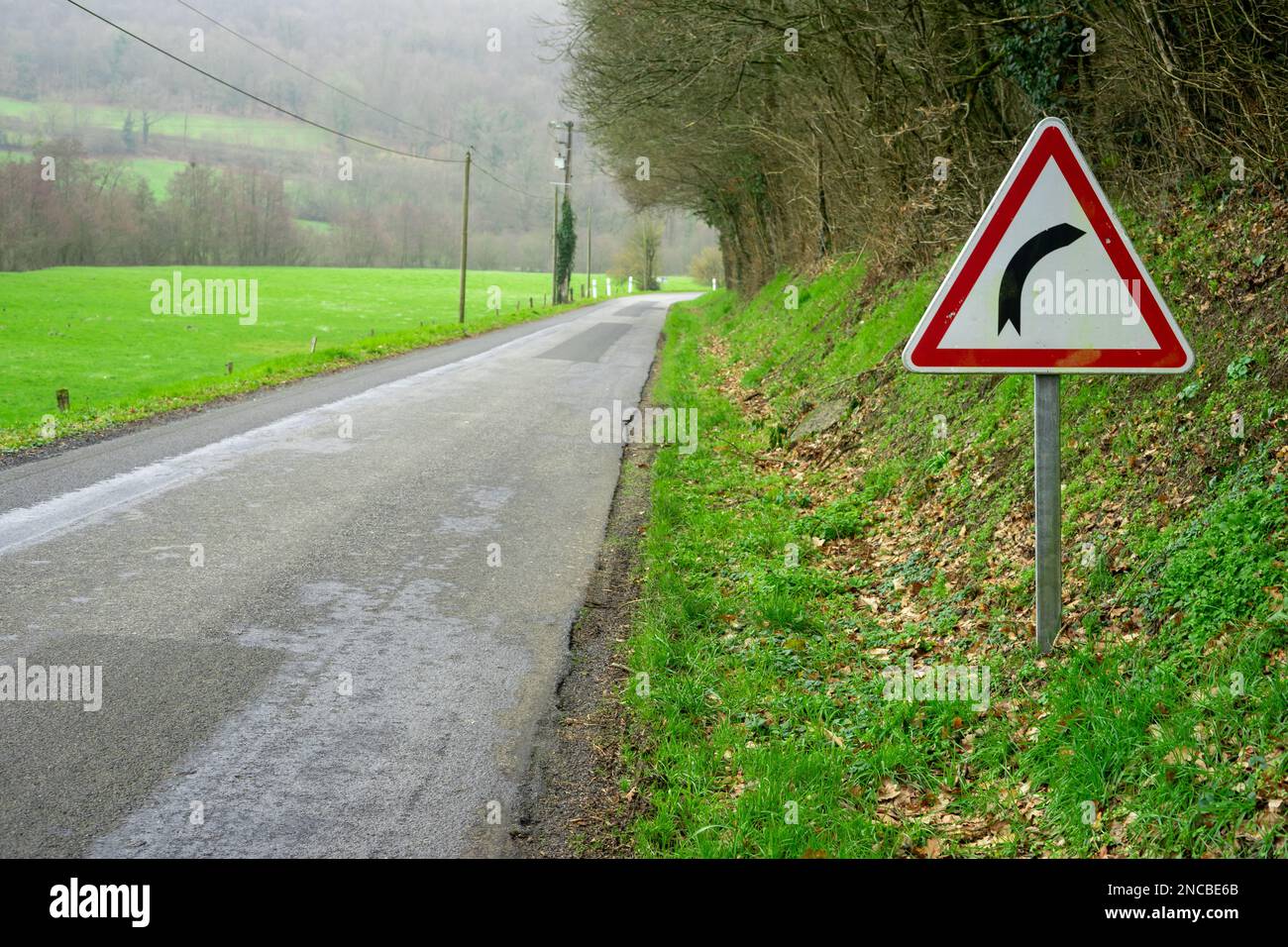 Road and road sign warning about a turn in the road. Road safety ...