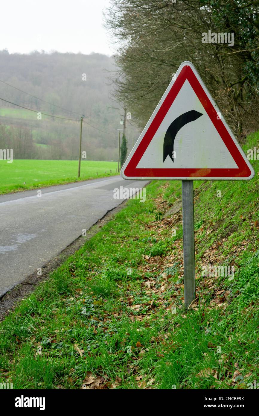 Road and road sign warning about a turn in the road. Road safety ...