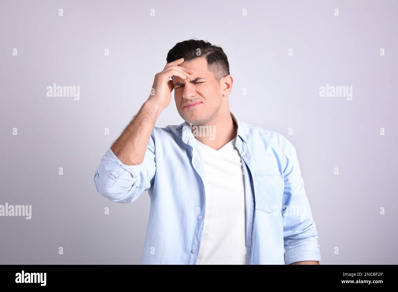 Portrait of stressed man on light background Stock Photo - Alamy