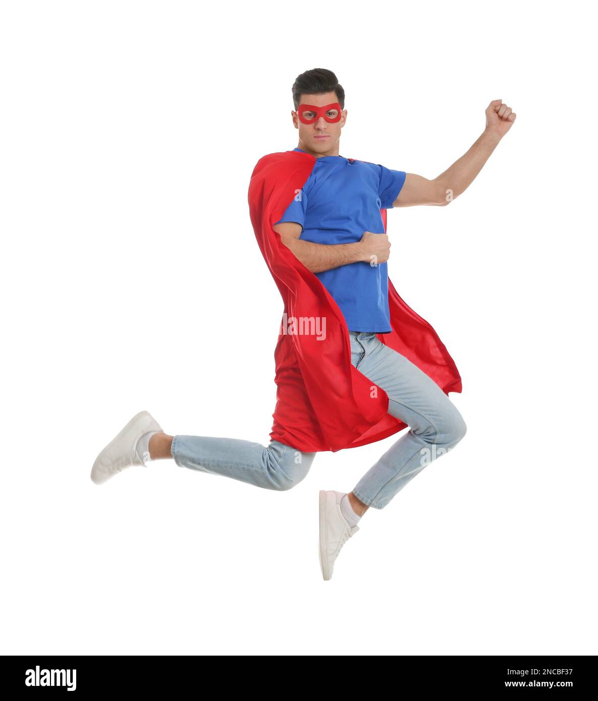 Man in superhero cape and mask jumping on white background Stock Photo ...