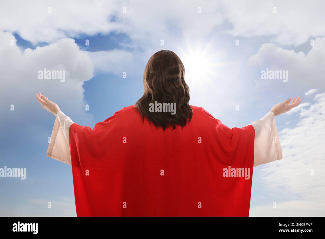 Jesus Christ with outstretched arms against blue sky, back view Stock ...