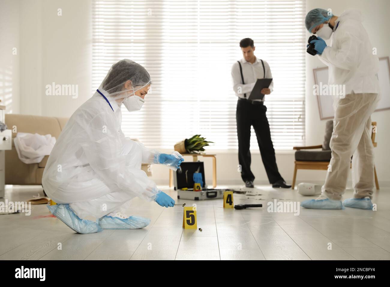 Investigators working at crime scene in messy room Stock Photo - Alamy