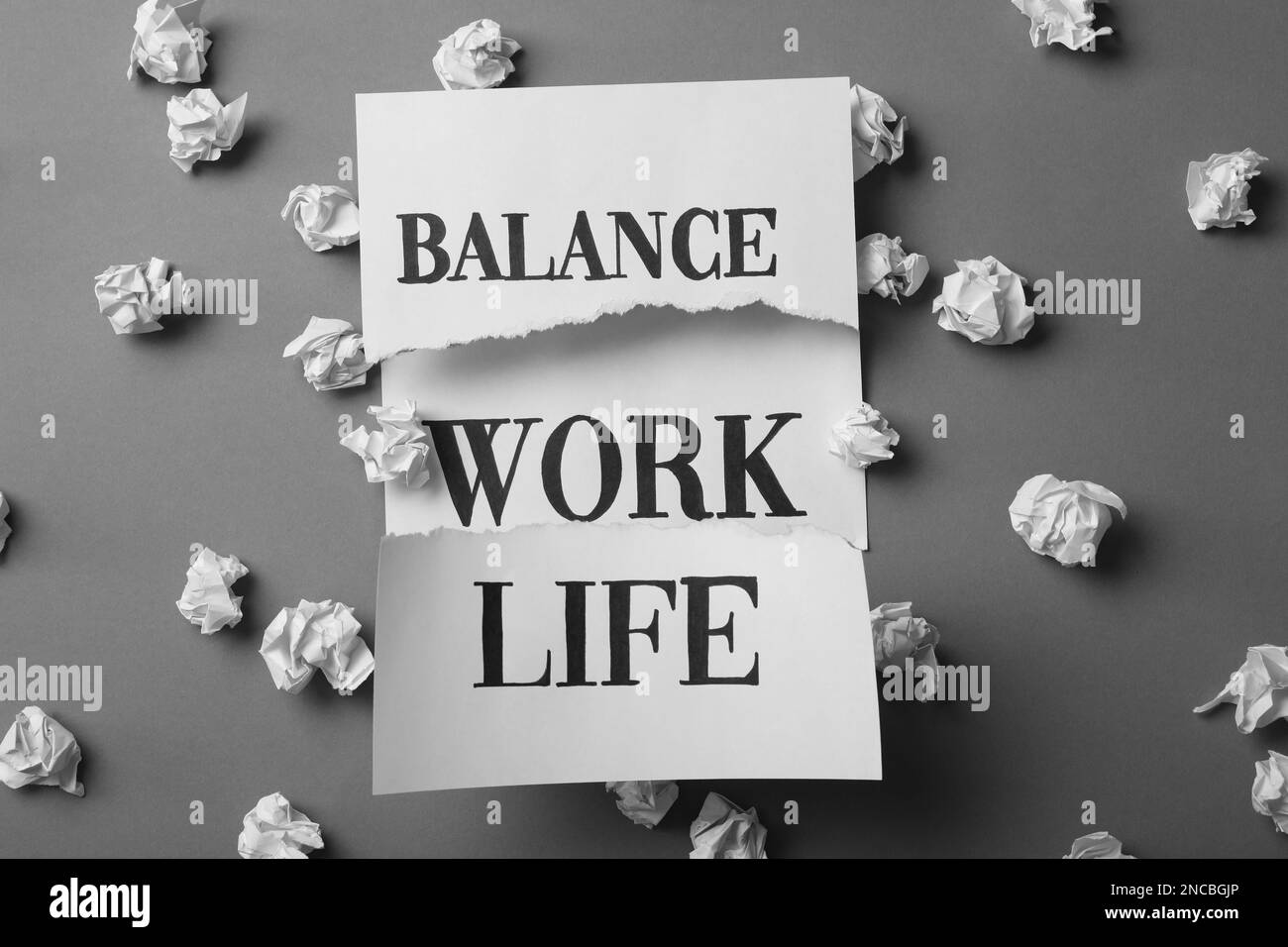 Crumpled paper and pieces on grey table flat lay. Life work balance ...