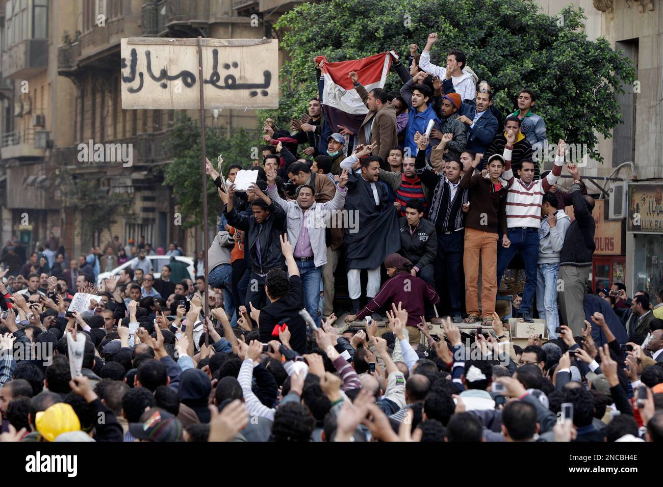 Egyptian anti-government protesters climb atop an Egyptian army armored ...