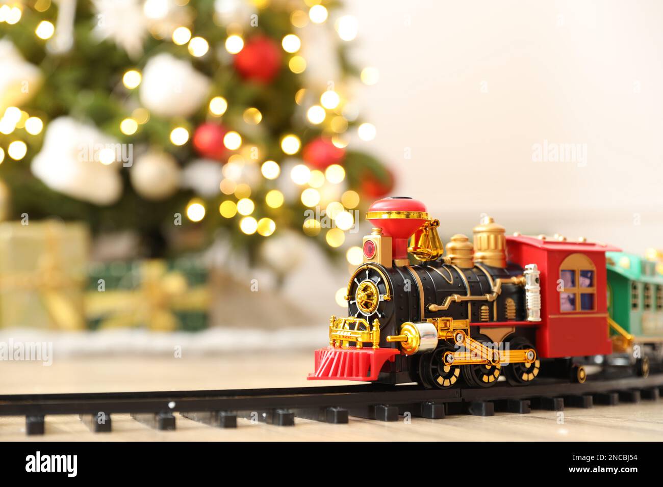 Toy train and railway on floor against Christmas lights Stock Photo - Alamy