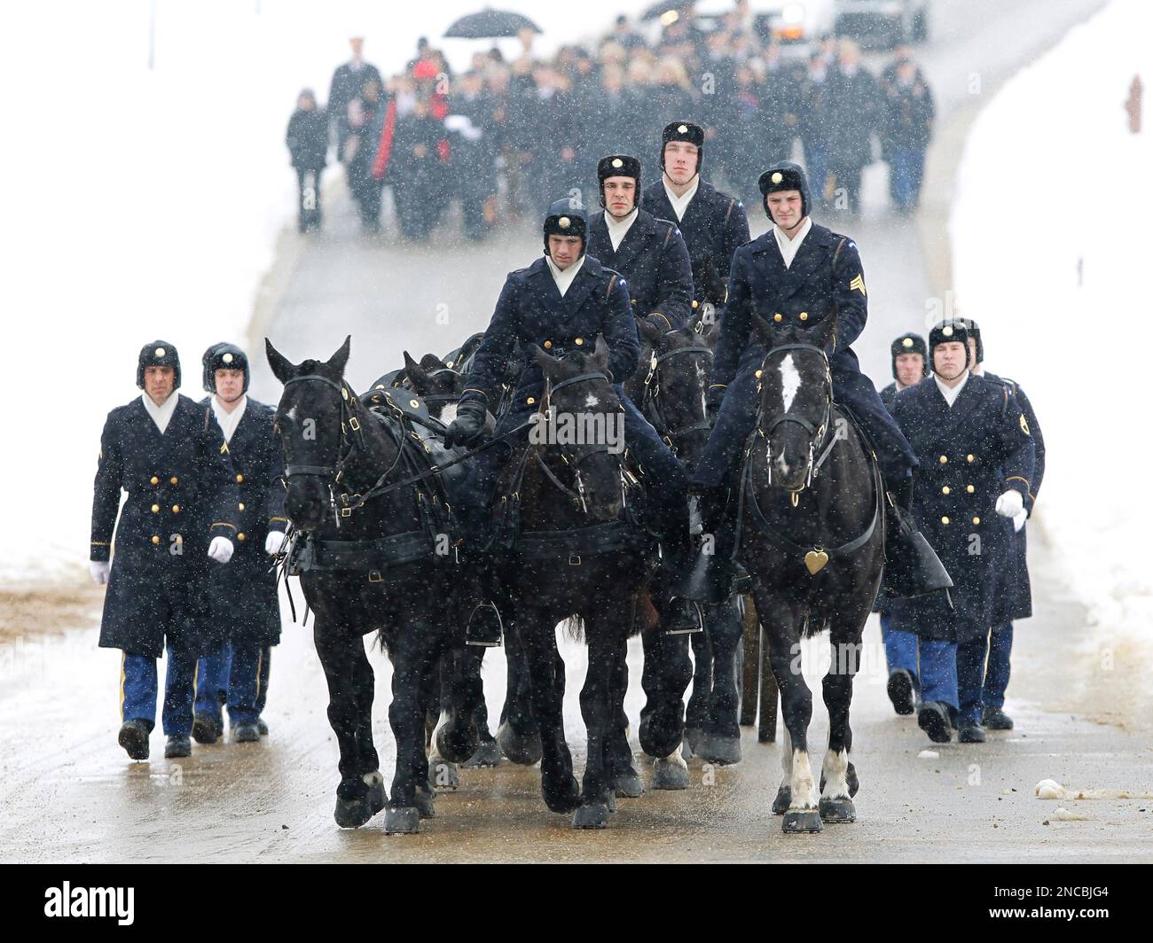 Snow falls as Army honor guards march with a horse-drawn caisson ...