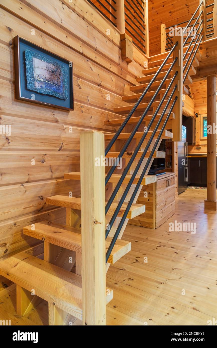 Staircase with wooden posts and black metal tubular handrail inside ...