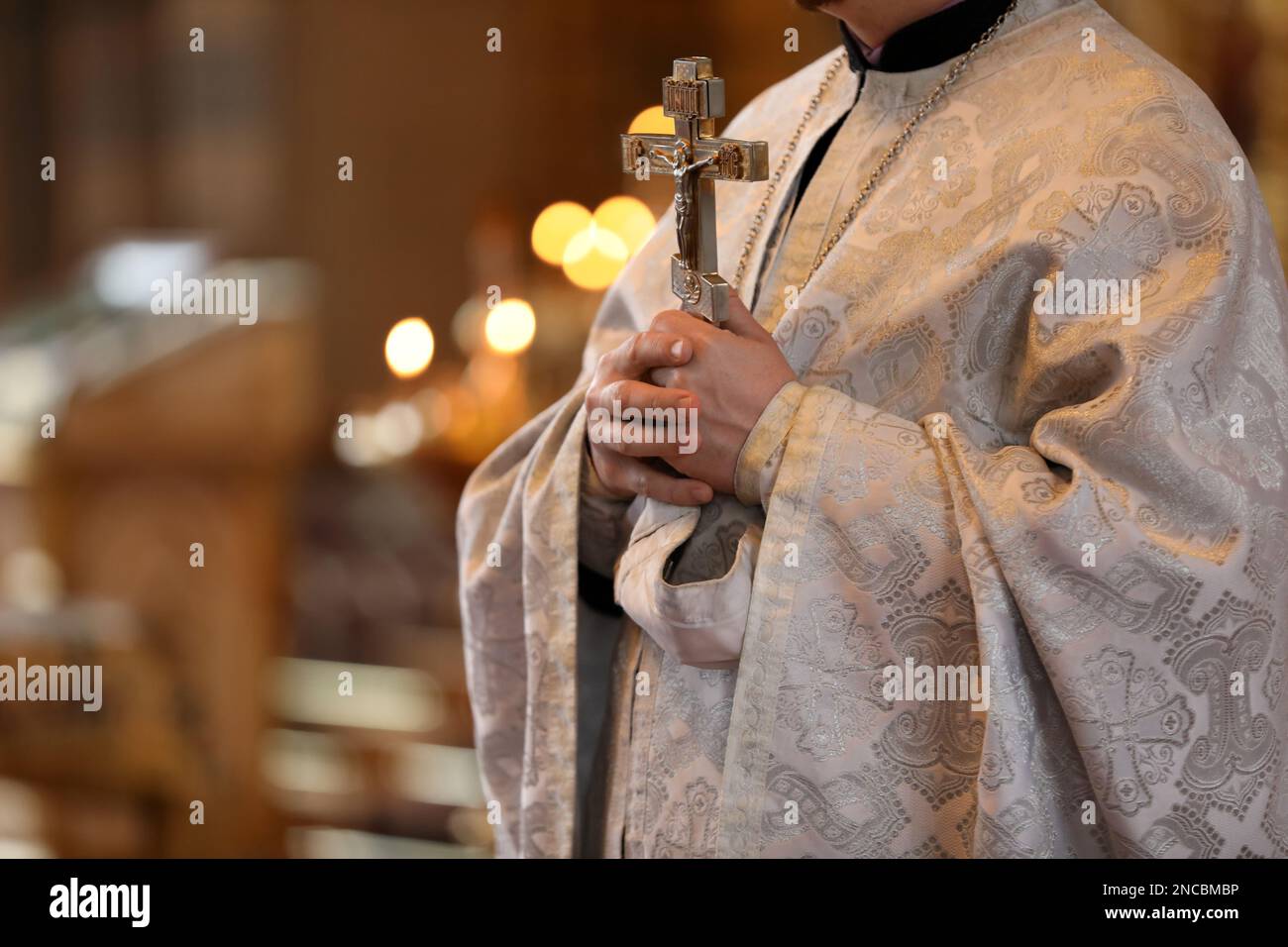 Priest holding cross in church during baptism ceremony, closeup Stock Photo - Alamy