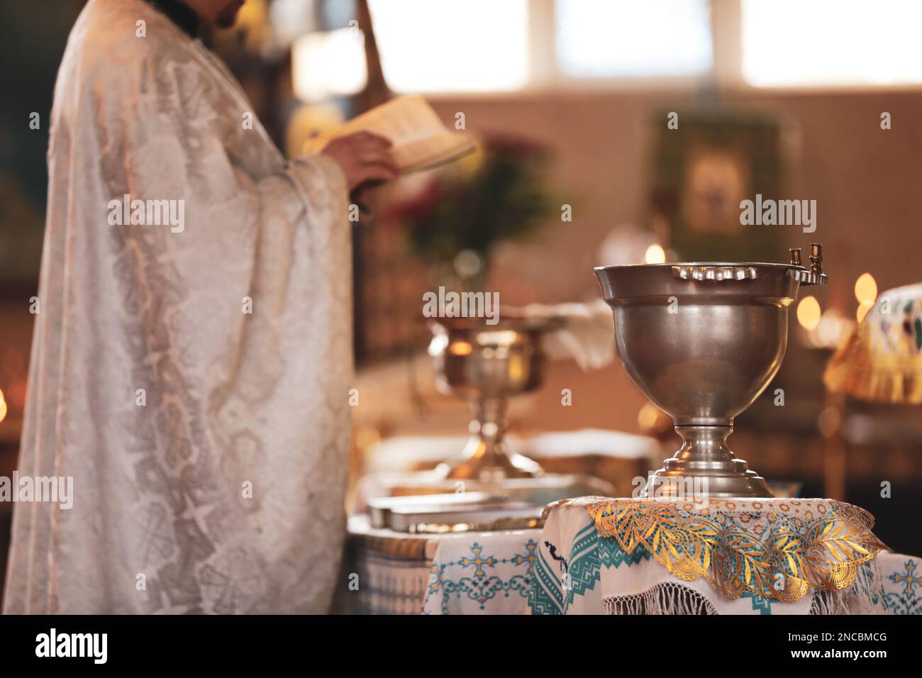 MYKOLAIV, UKRAINE - FEBRUARY 27, 2021: Priest conducting baptism ...