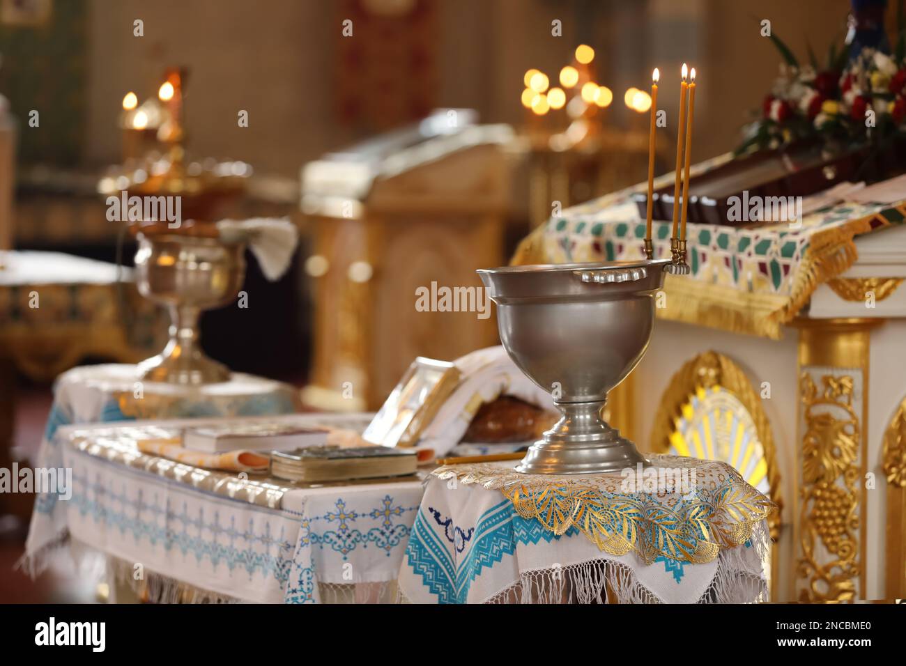 Silver vessel with holy water on stand near altar in church, space for ...