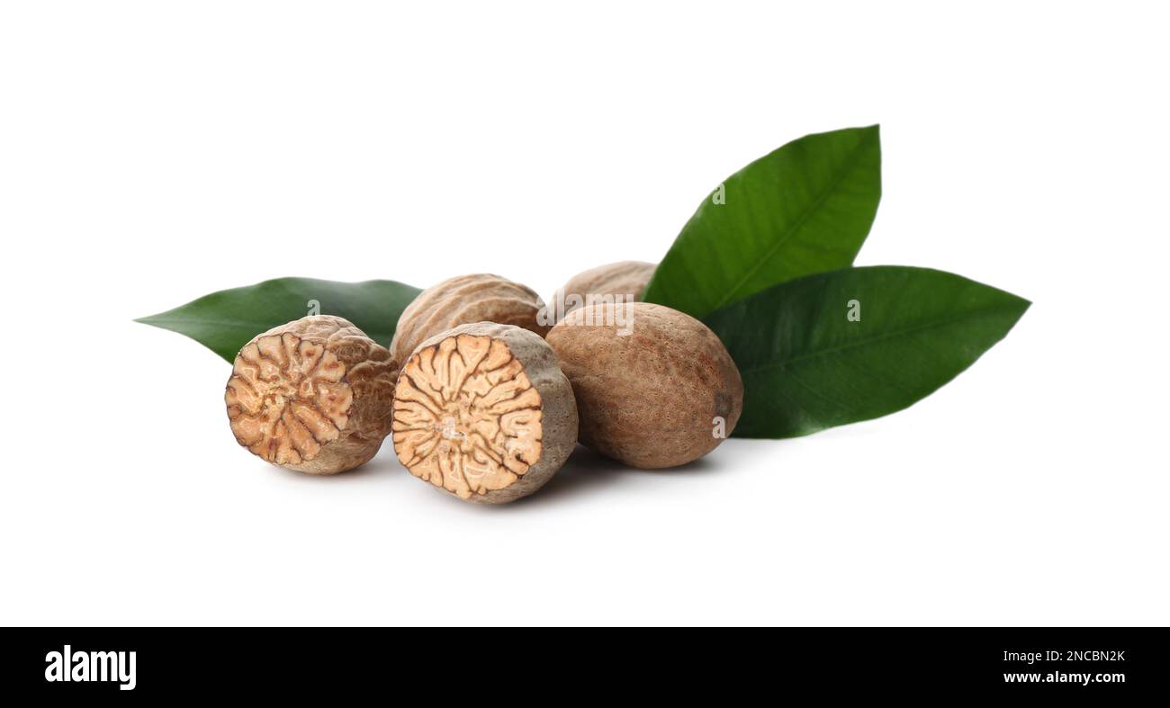 Nutmeg seeds with green leaves on white background Stock Photo - Alamy