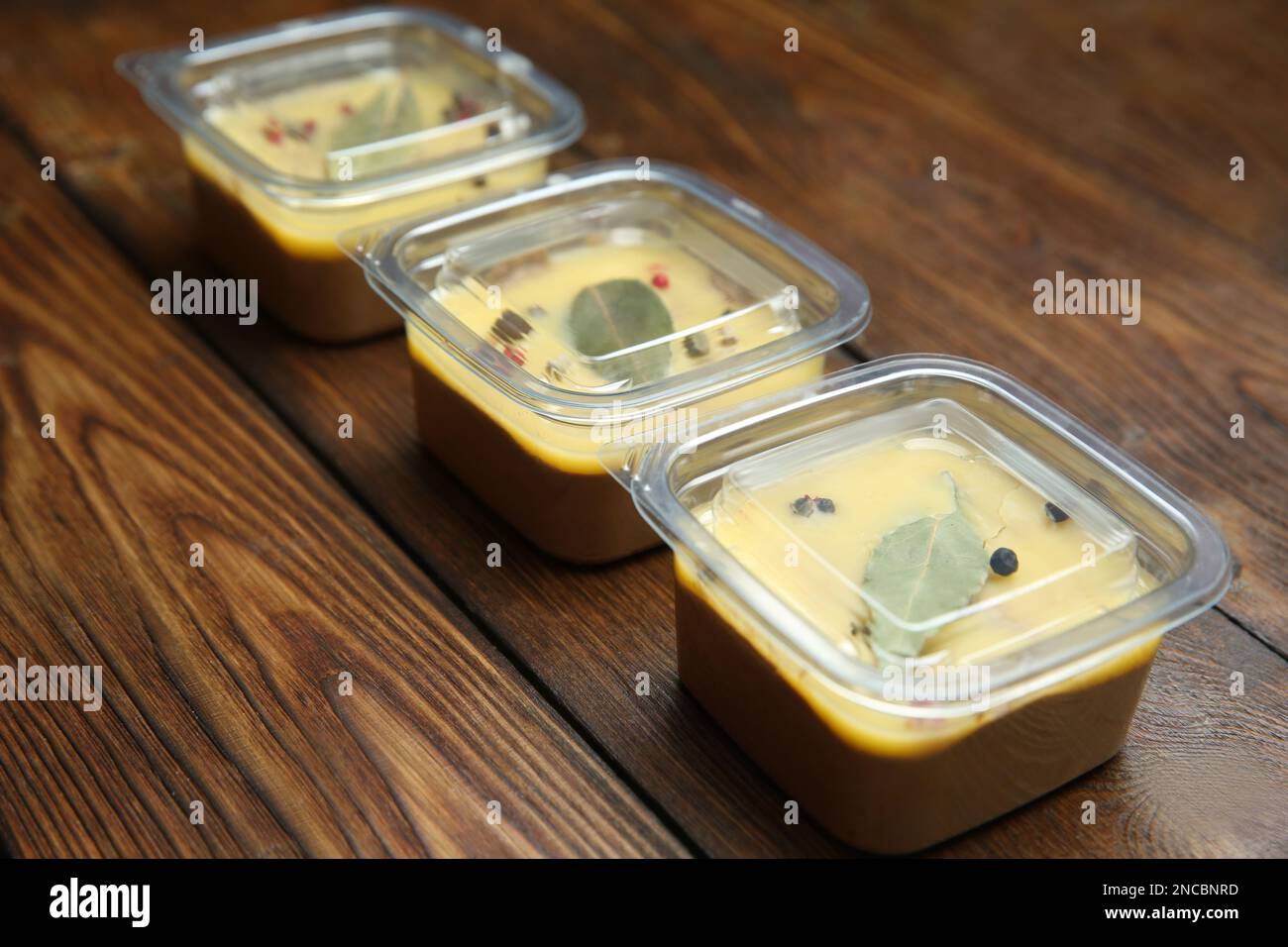 Delicious chicken liver pate in plastic containers on wooden table ...