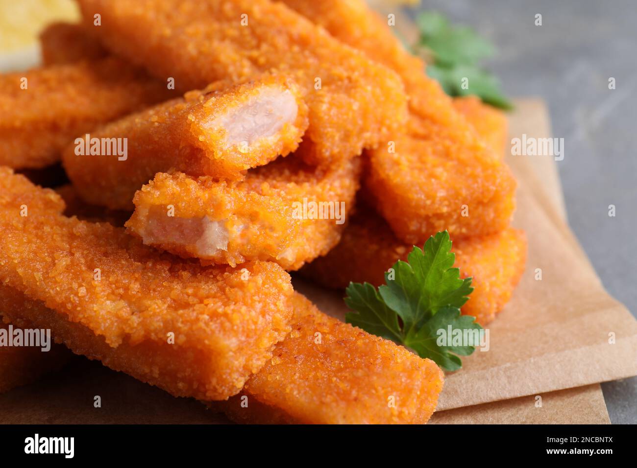 Fresh breaded fish fingers on parchment, closeup Stock Photo - Alamy