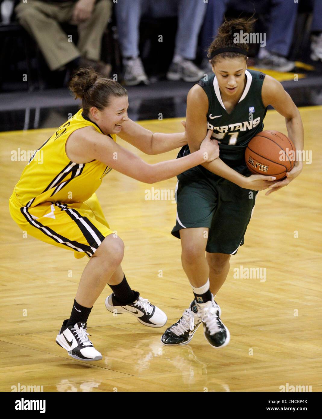 Iowa forward Kalli Hansen, left, grabs the arm of Michigan State guard ...