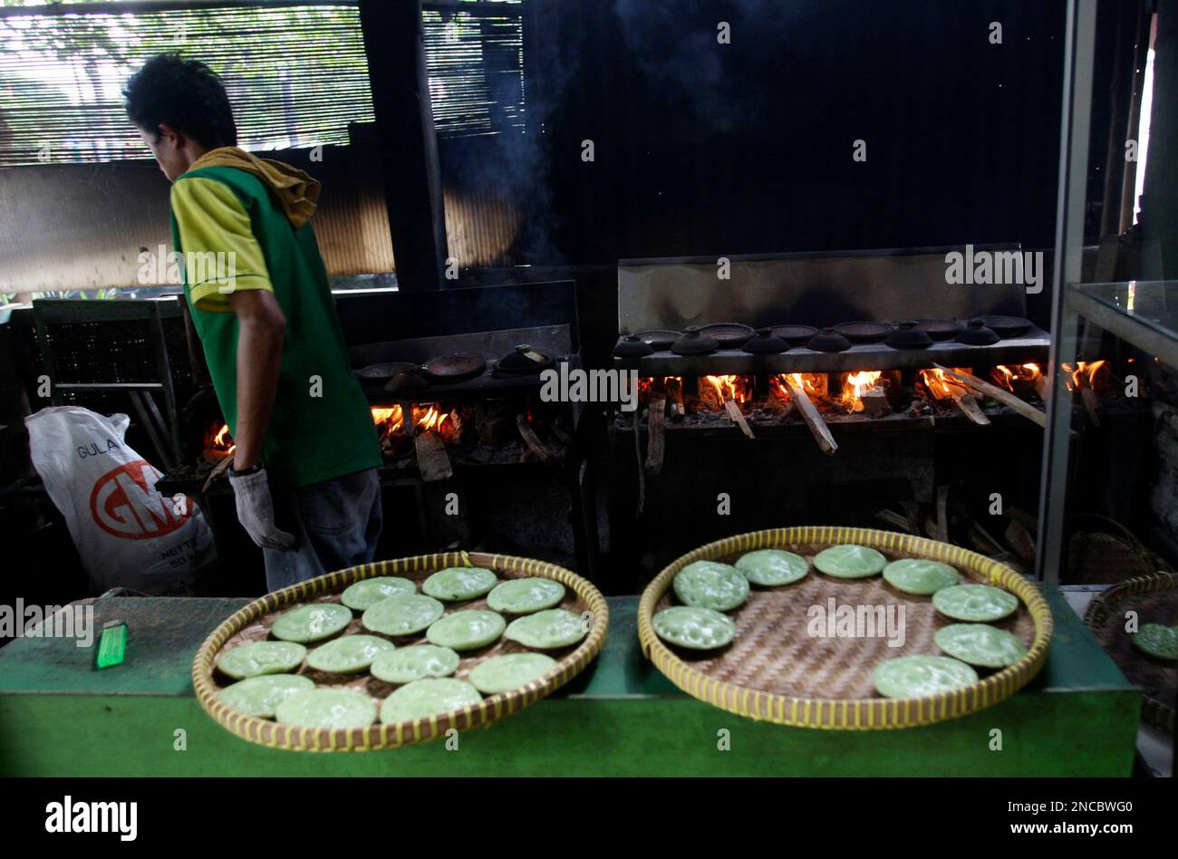 Indonesian man cook traditional pancake at a food stall in Jakarta ...