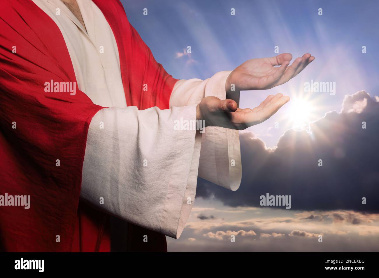 Jesus Christ reaching out his hands and praying against blue sky Stock ...