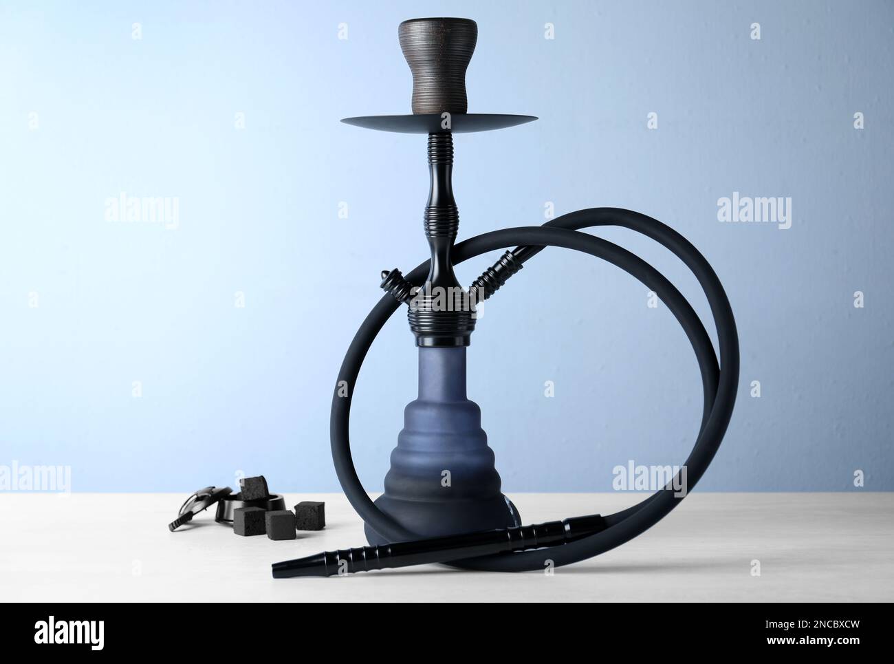 Traditional hookah on white table against light blue background Stock ...