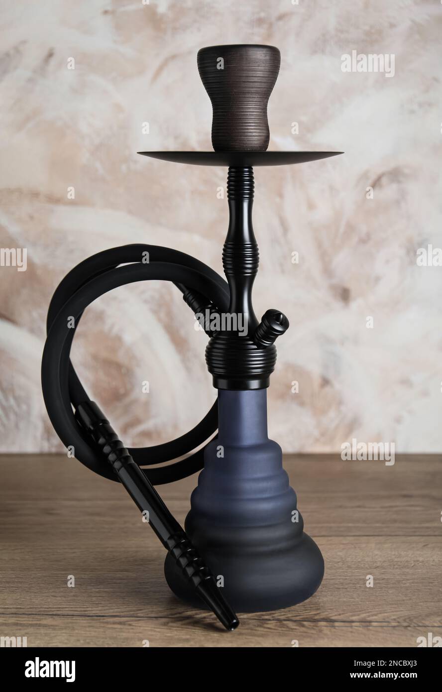 Beautiful traditional hookah on wooden table against light background ...