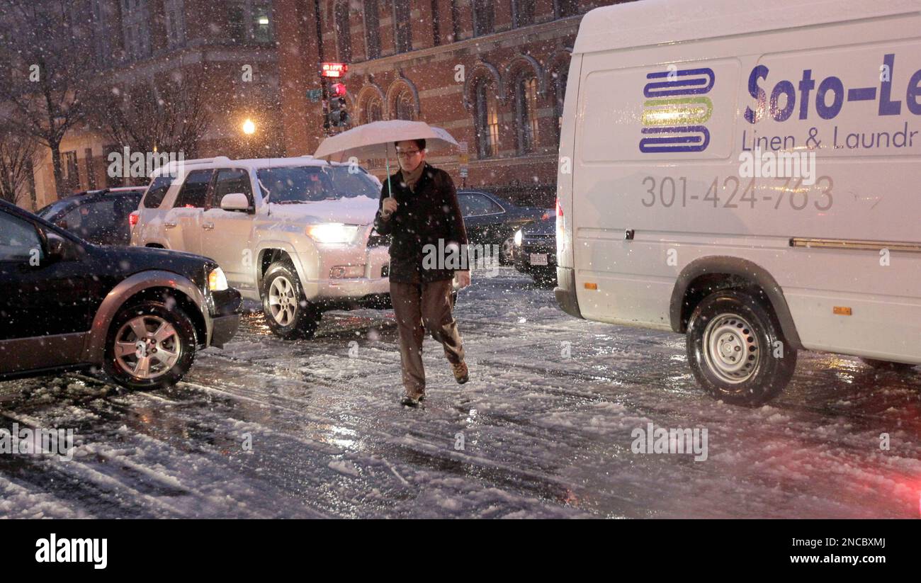 A pedestrian walks through a traffic-clogged intersection of downtown ...