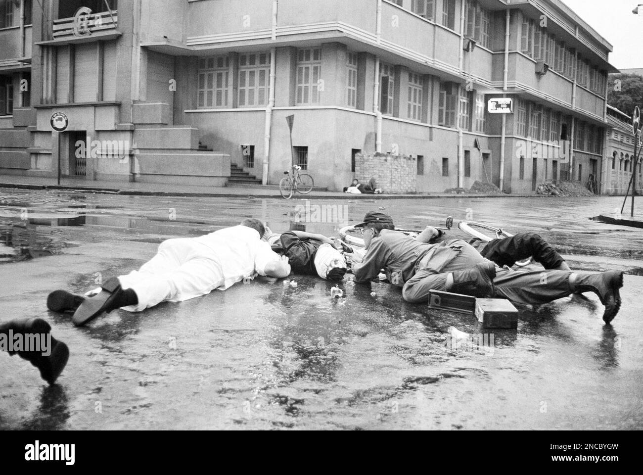 An American medic and an American MP crawl toward three Vietnamese ...