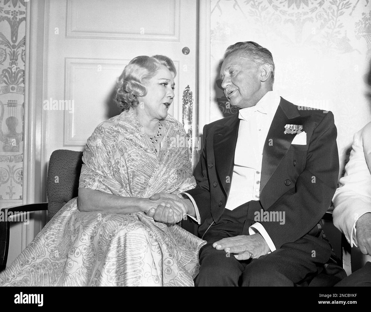 Jean Hersholt, veteran actor, holds hands with Mary Pickford during a ...