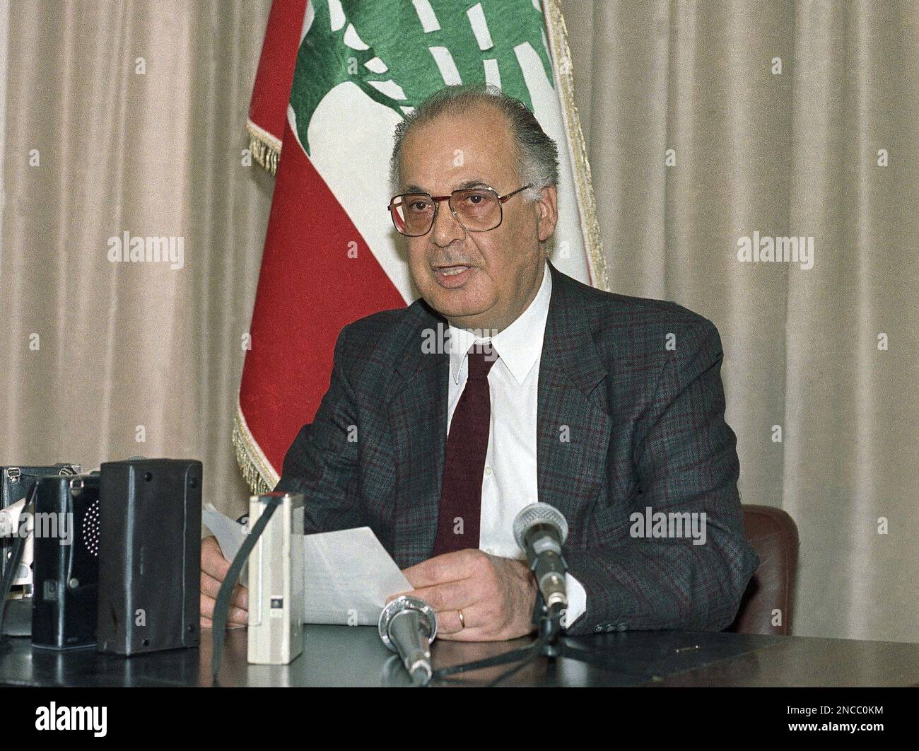 Prime Minister Salim Al Hoss with glasses and Lebanese flag next to him ...