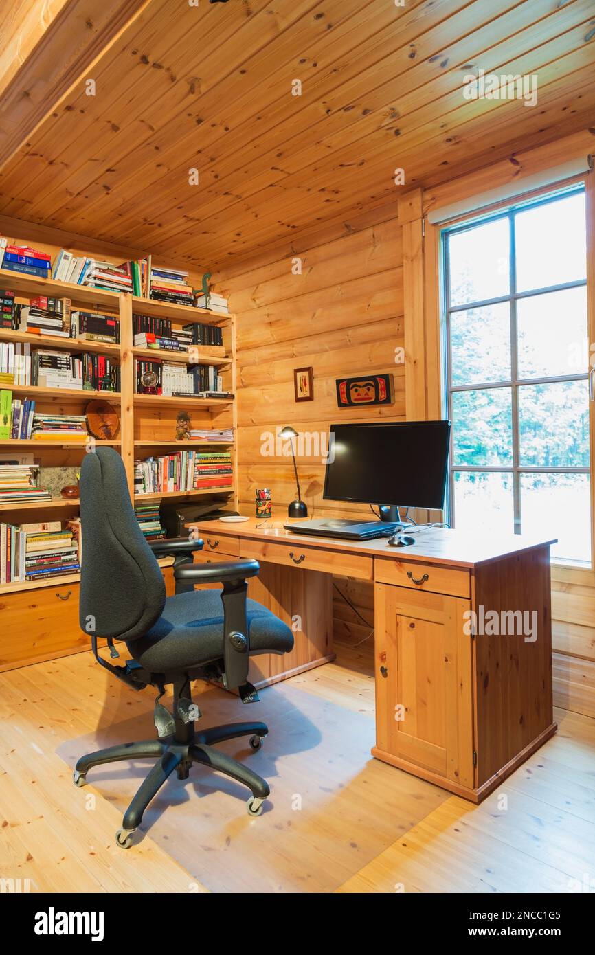 Black upholstered swivel office chair and wooden desk with computer ...