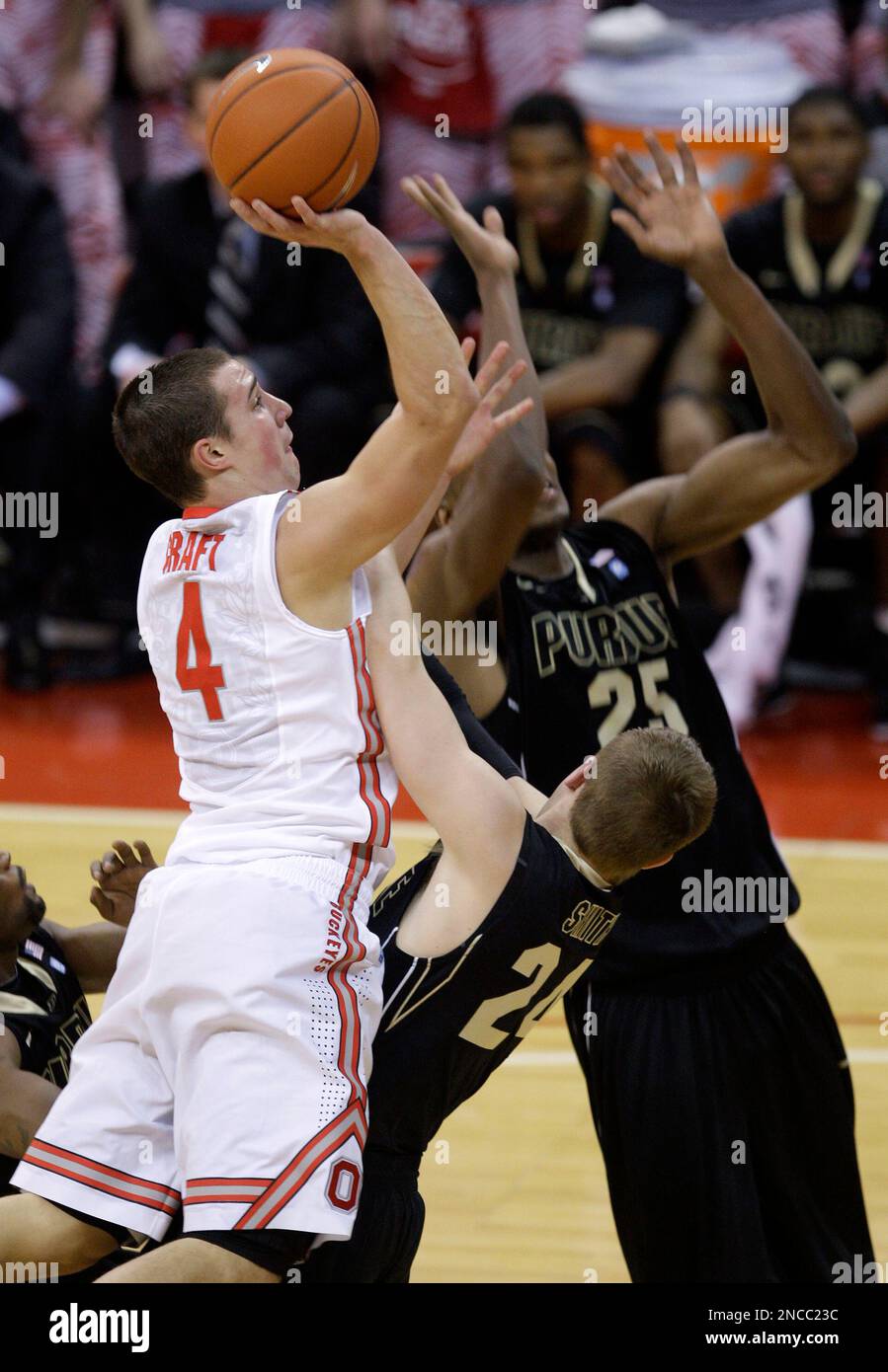 Ohio State's Aaron Craft, left, shoots over Purdue's Ryne Smith, center ...