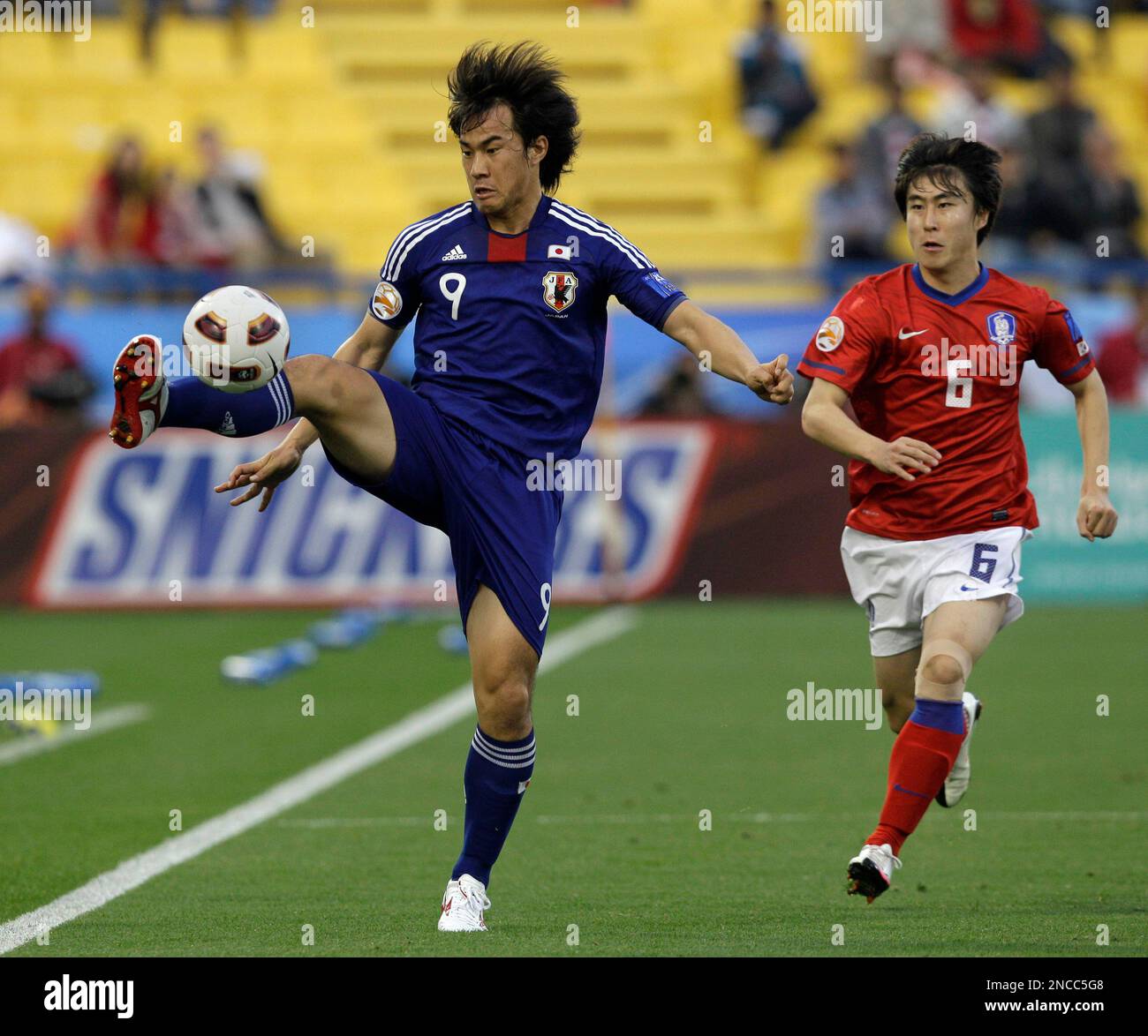 Japan's Shinji Okazaki, left, fights for the ball against South Korea's ...