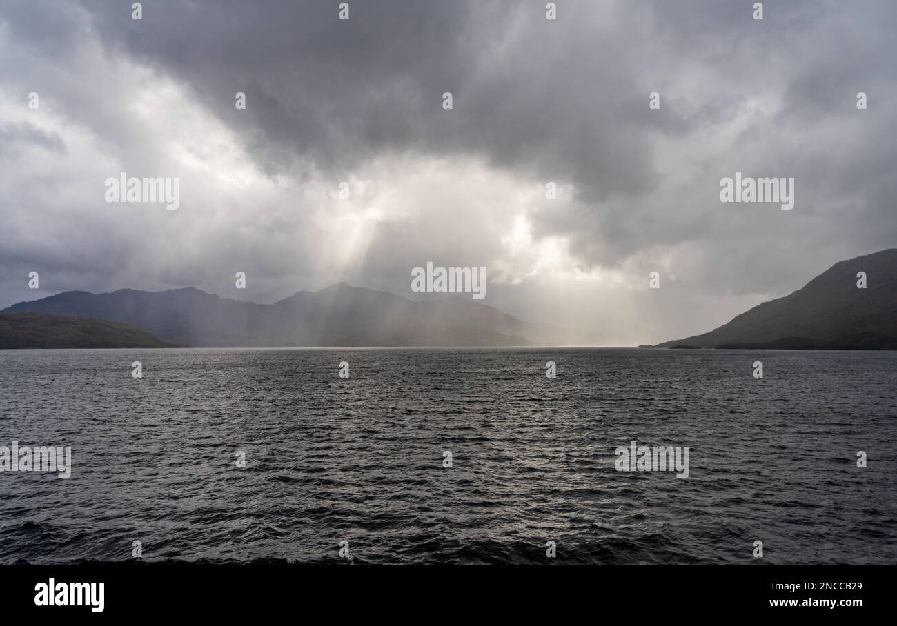 Rain over the mountains as cruise ship with swimming pool sails through ...