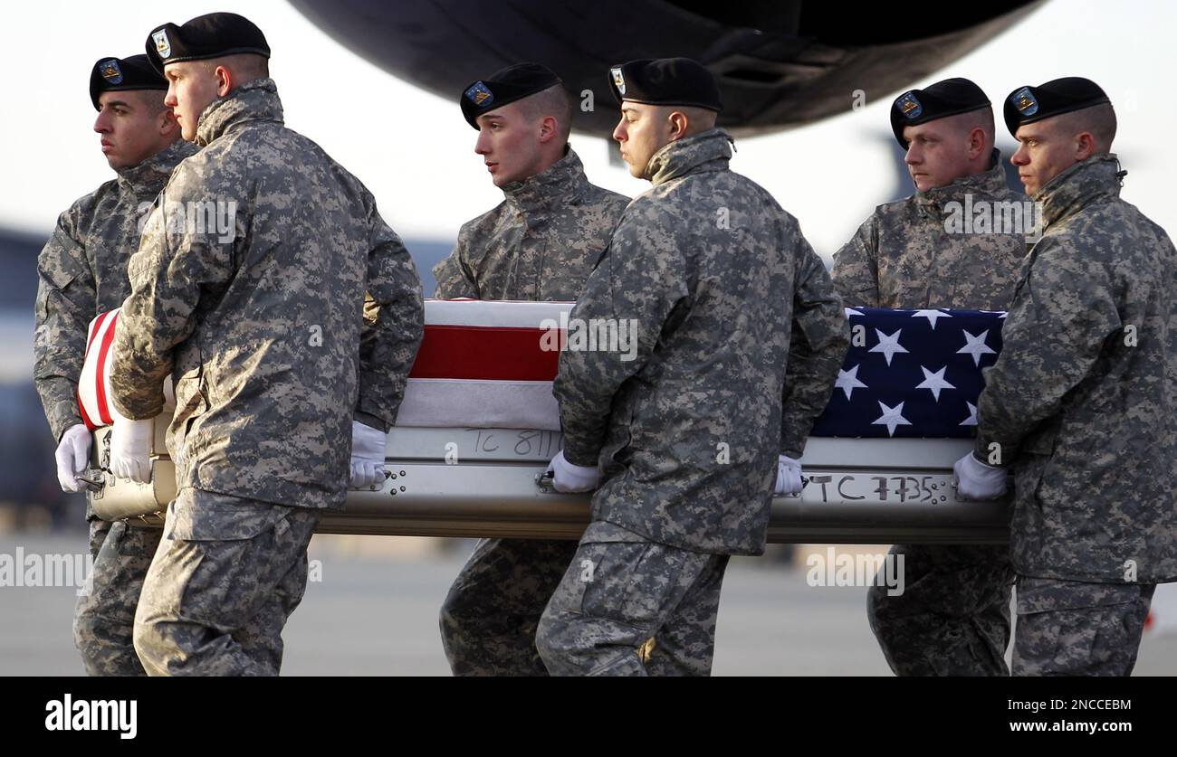 An Army carry team carries the transfer case containing the remains of ...