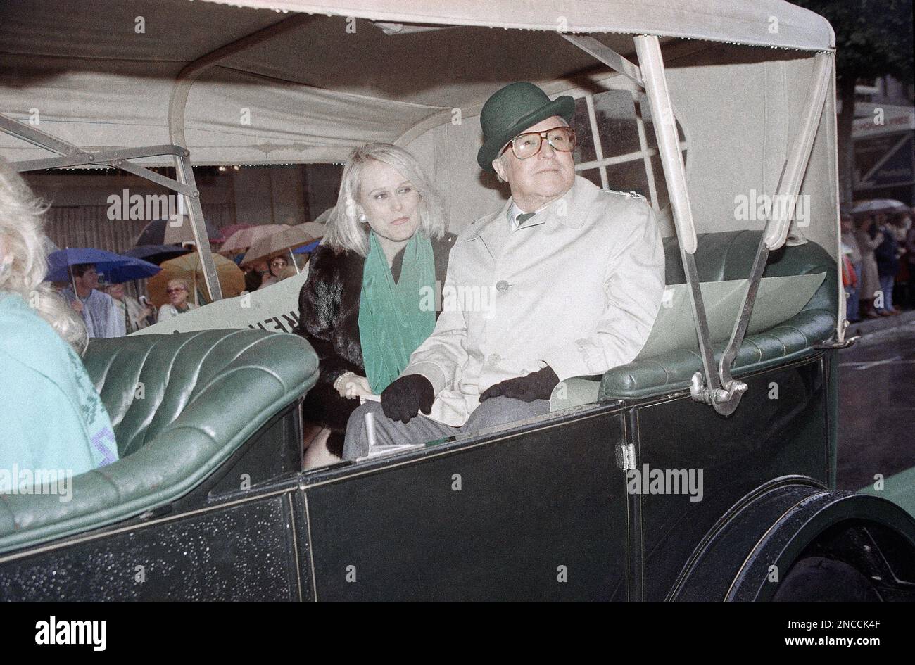 Actor Gene Kelly sits in a vintage automobile with his companion Sandy Bennett in Los Angeles on ...