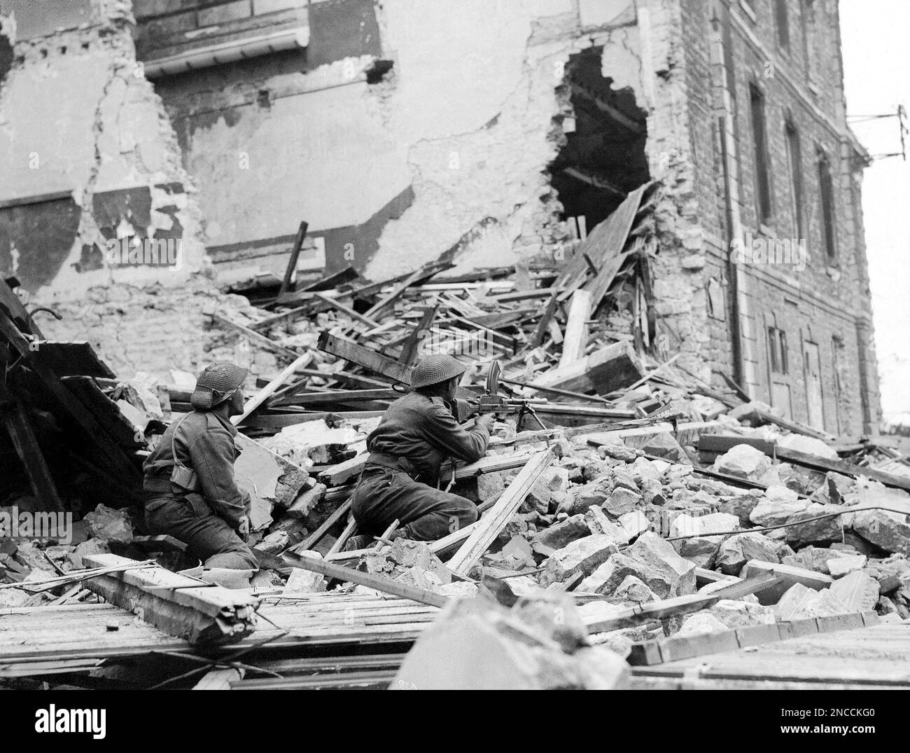 Two Canadian Bren gunners are on alert in the rubble of a damaged ...