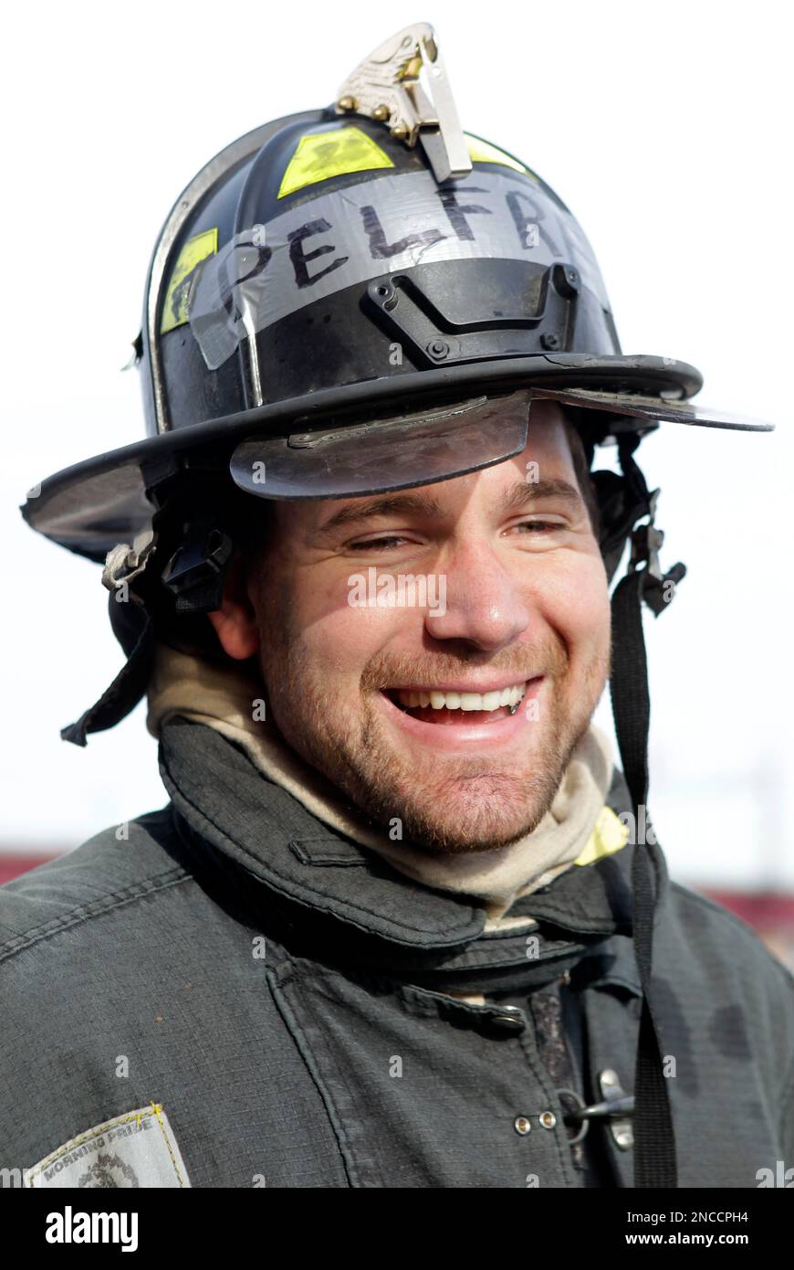 New York Mets' pitcher Mike Pelfry laughs while in full fire gear at a ...