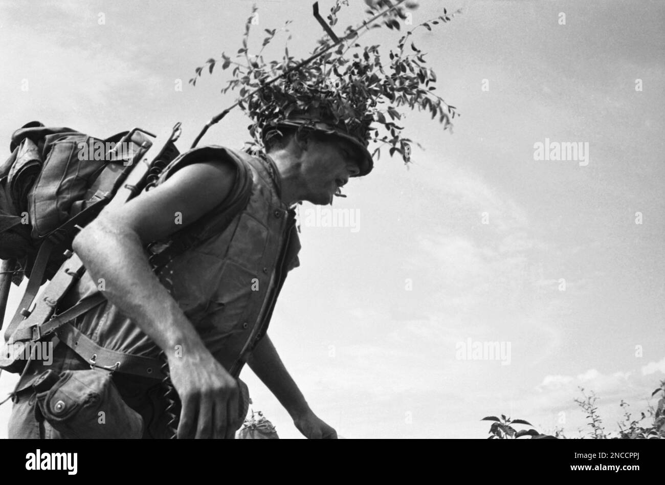 A U. S. Marine, carrying bandolier with M79 grenades, races for cover ...