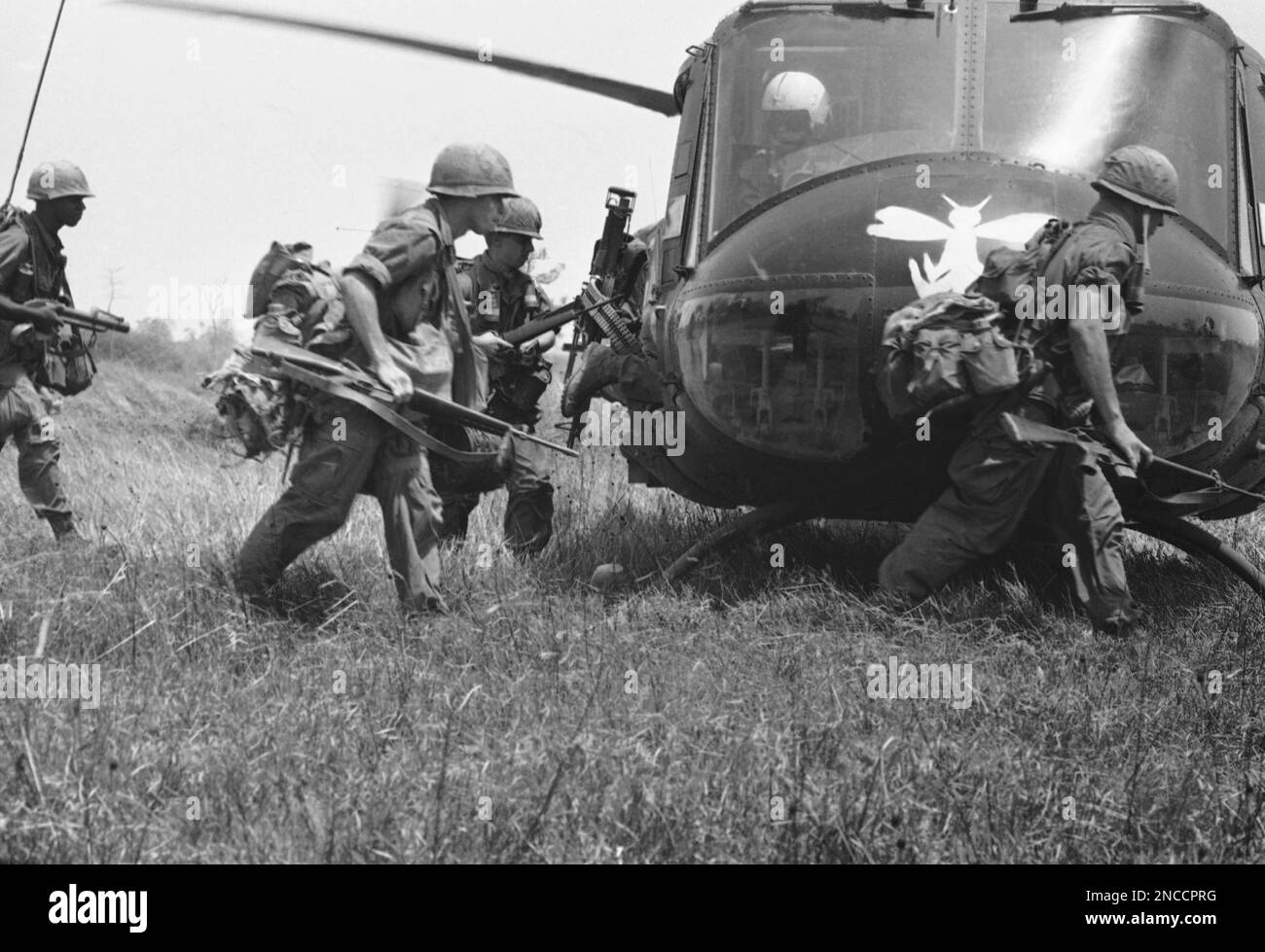 U.S. paratroopers dash across clearing to helicopters that will lift ...