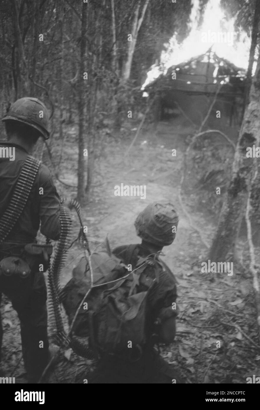 U.S. paratroopers stream machine gun rounds into bunker next to burning ...