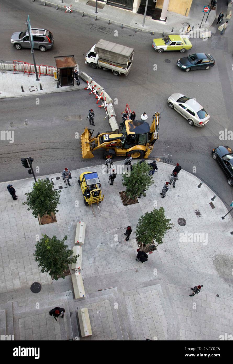 Lebanese police officers place cement blocks around the government ...